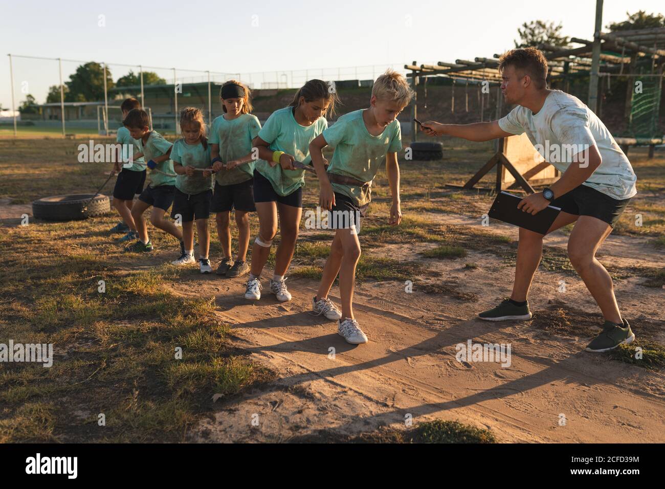 Group of kids pulling a rope tied to a tire at a boot camp Stock Photo ...