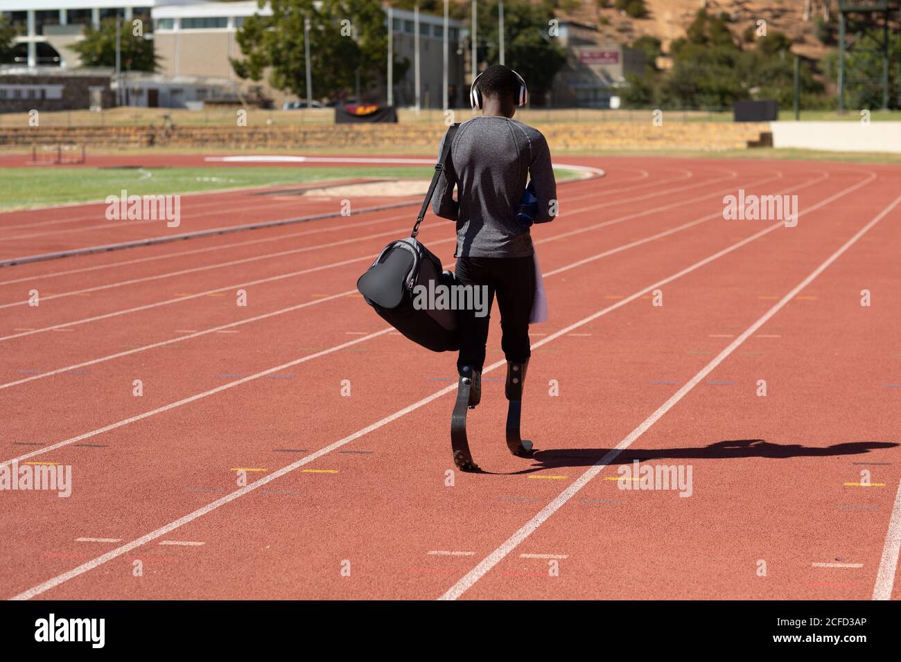 Rear view of male athlete walking on race track Stock Photo - Alamy