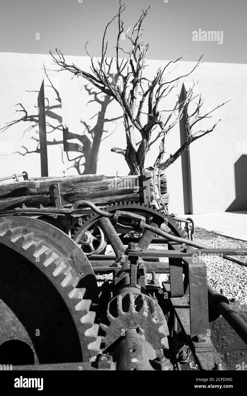 Contrast of old heavy machinery and dead casting shadow on wall behind ...