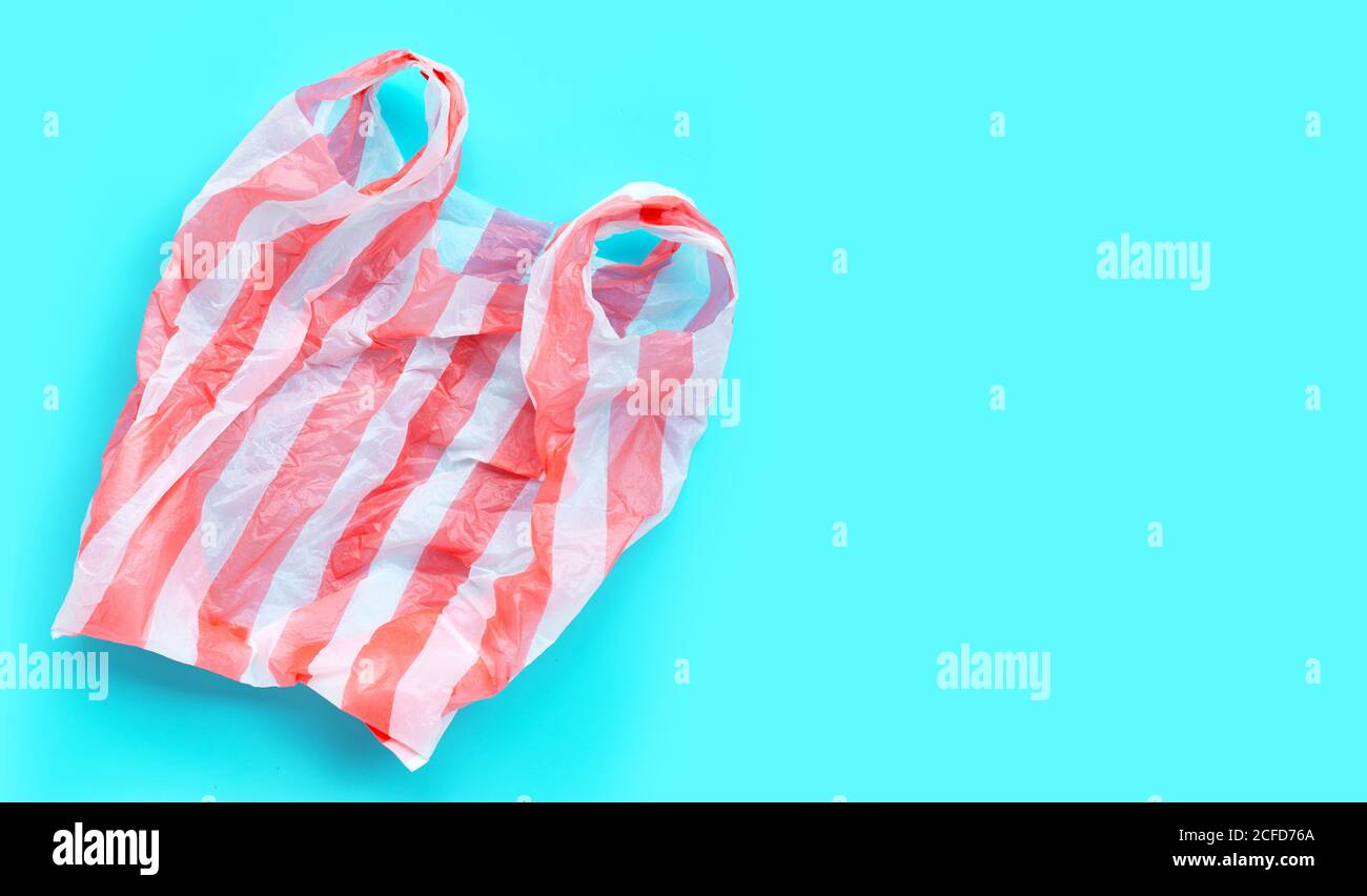 Colorful plastic bag on blue background. Copy space Stock Photo - Alamy