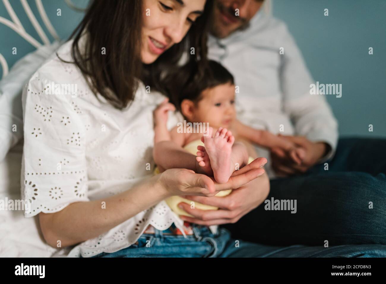 Parents hugging baby on bed Stock Photo - Alamy