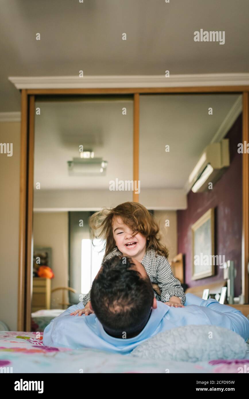faceless dad having fun with happy daughter holding on hands while ...