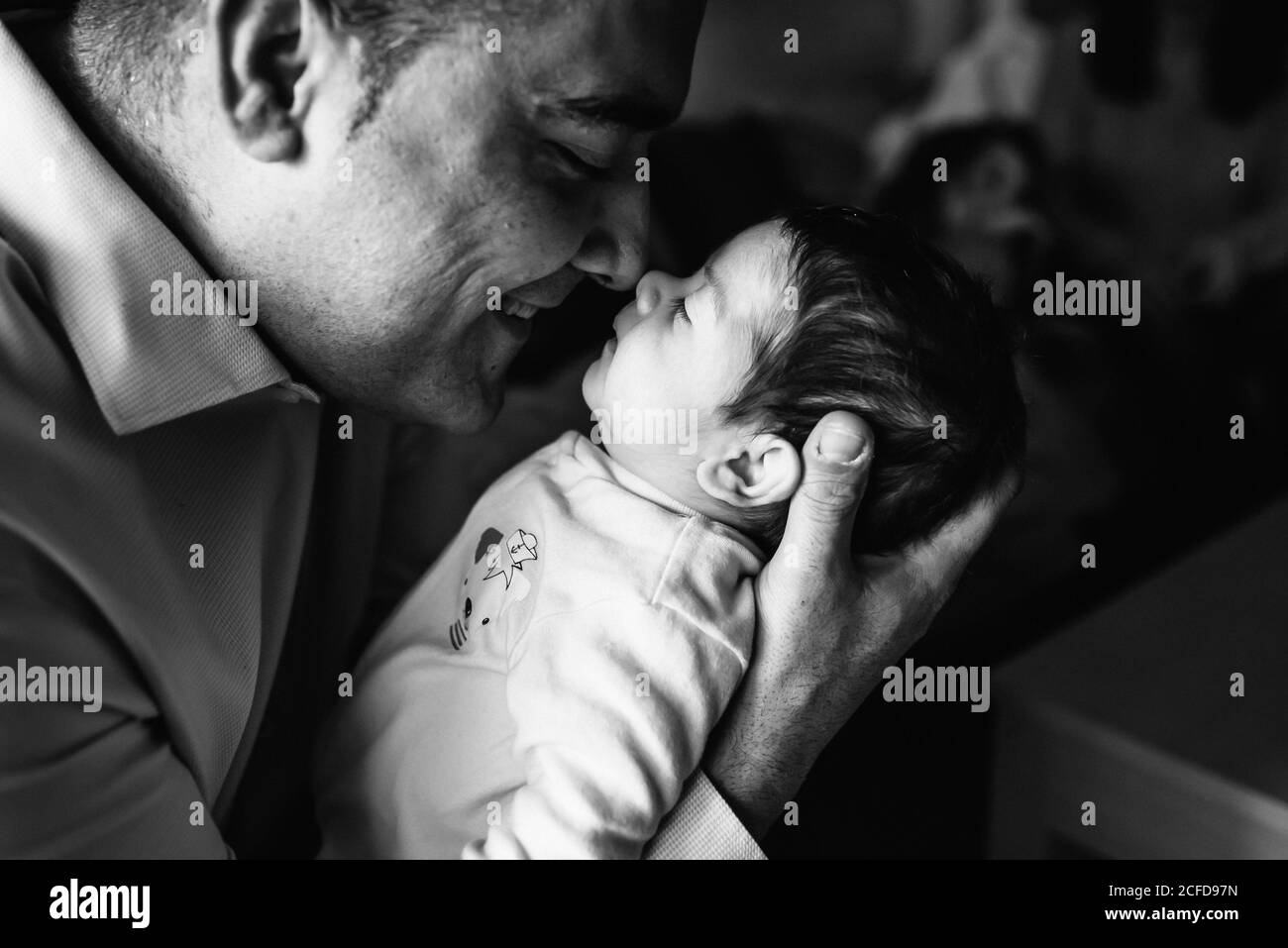 father hugging cute little baby looking away at home Stock Photo - Alamy