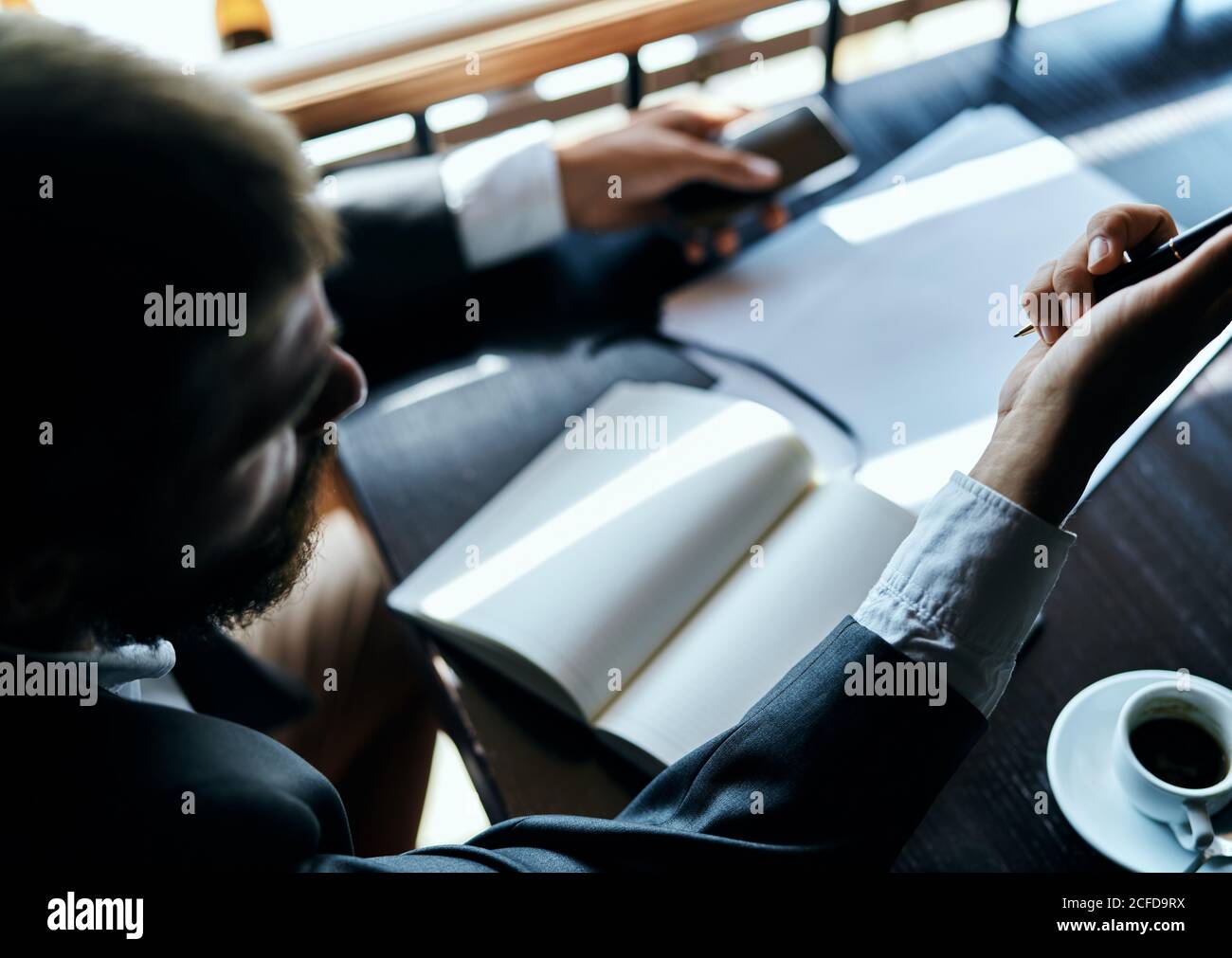 Business man in a cafe documents a cup of coffee on the table official ...