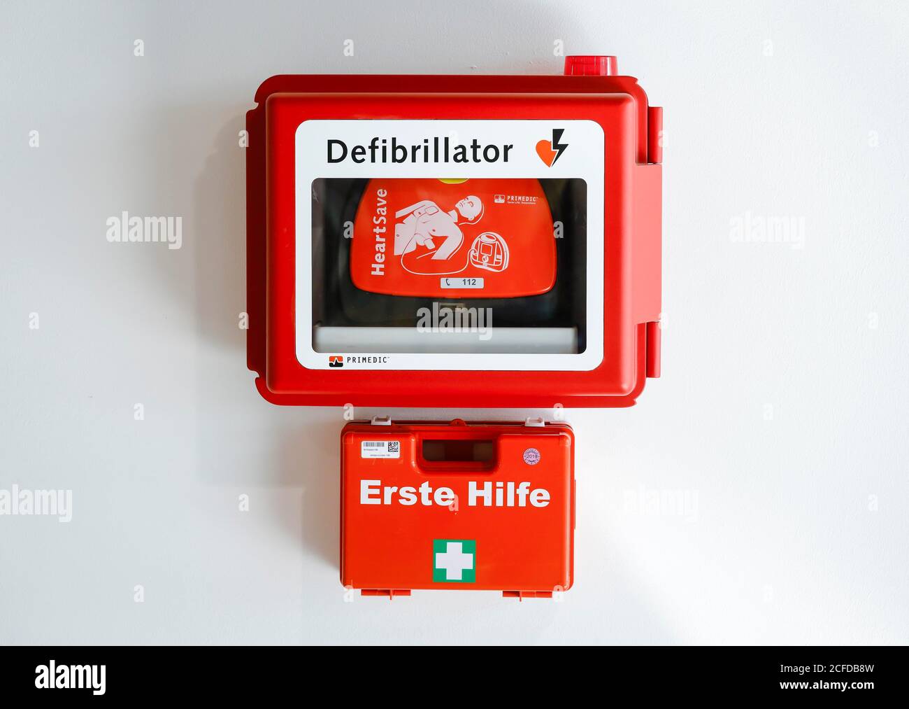 Defibrillator and first aid kit hanging on a wall in public space at ...