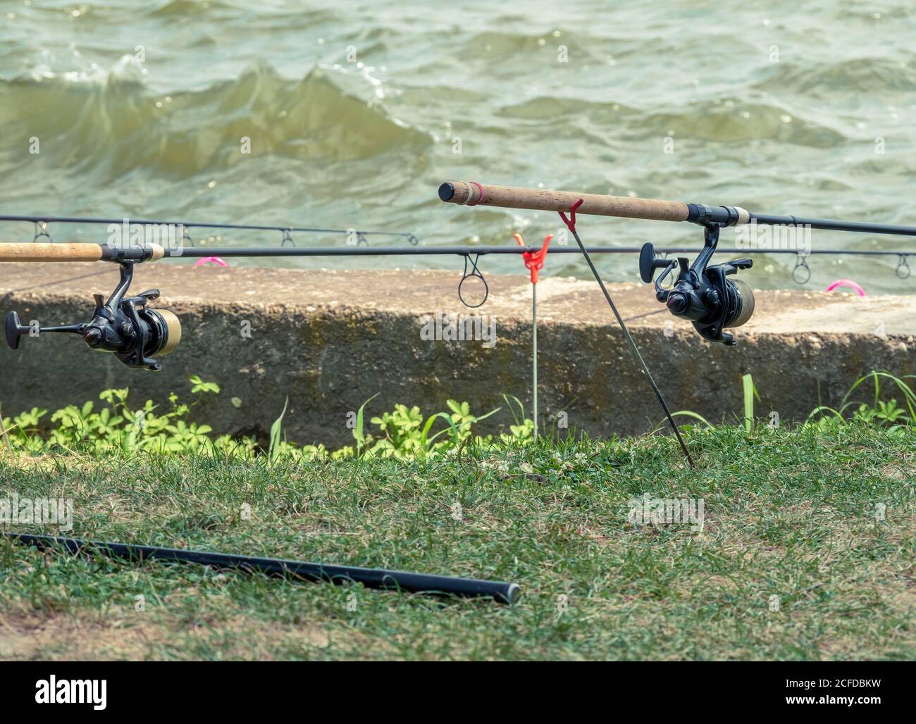 Fishing rod with spinning and reel at the edge of a lake Stock Photo ...