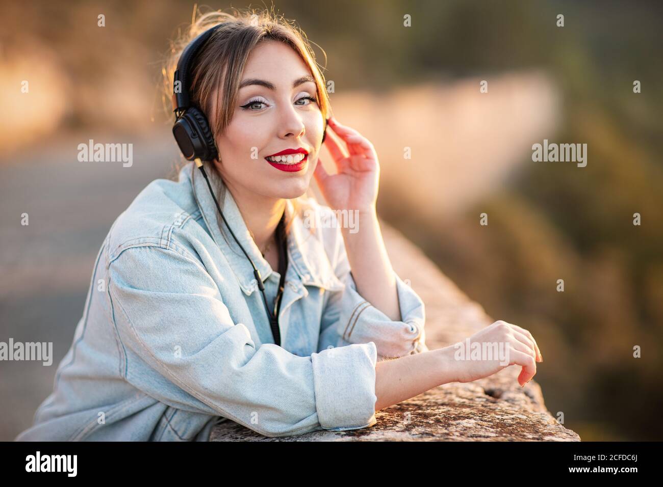 Side view of happy smiley young lady in stylish casual wear and red ...