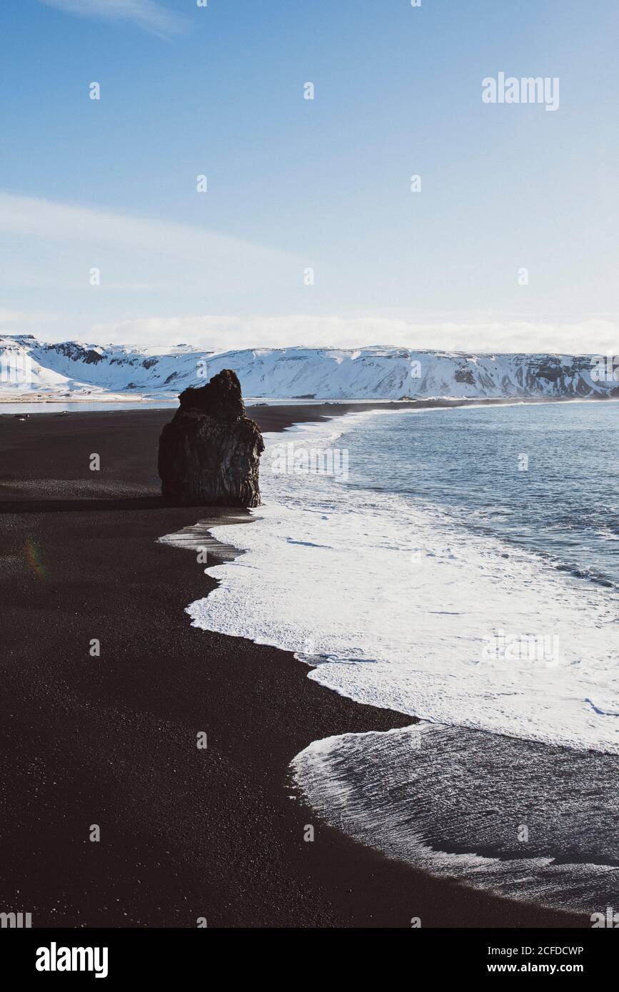 black lava beach of Reynisfjara with stand-alone rock at Cape of ...