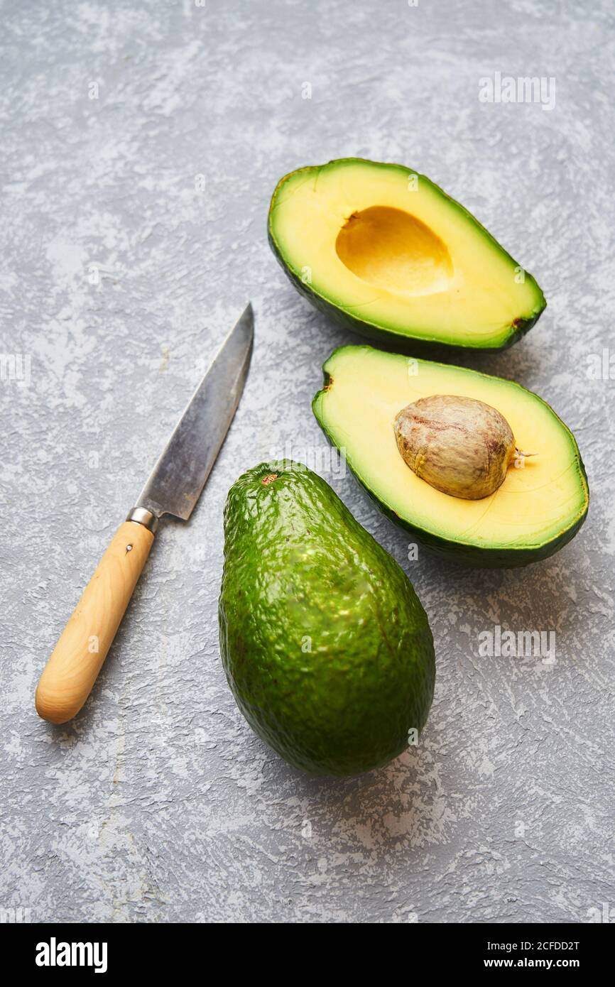 Cut avocado on grey texture background Stock Photo - Alamy