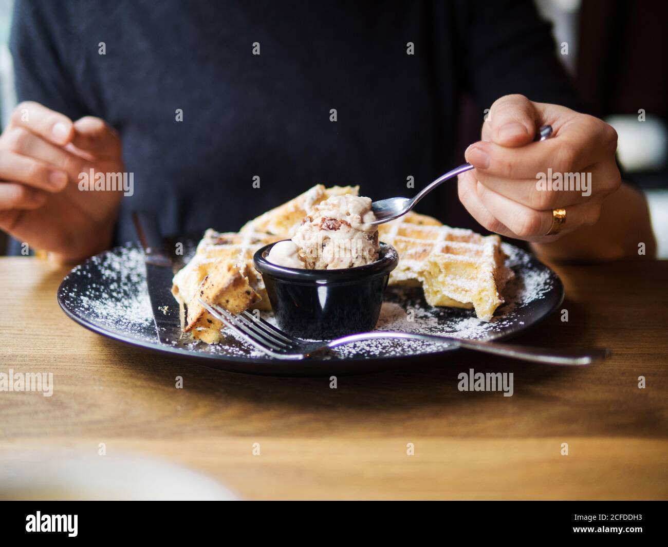unrecognizable person enjoying cold sweet ice cream and fresh waffles ...