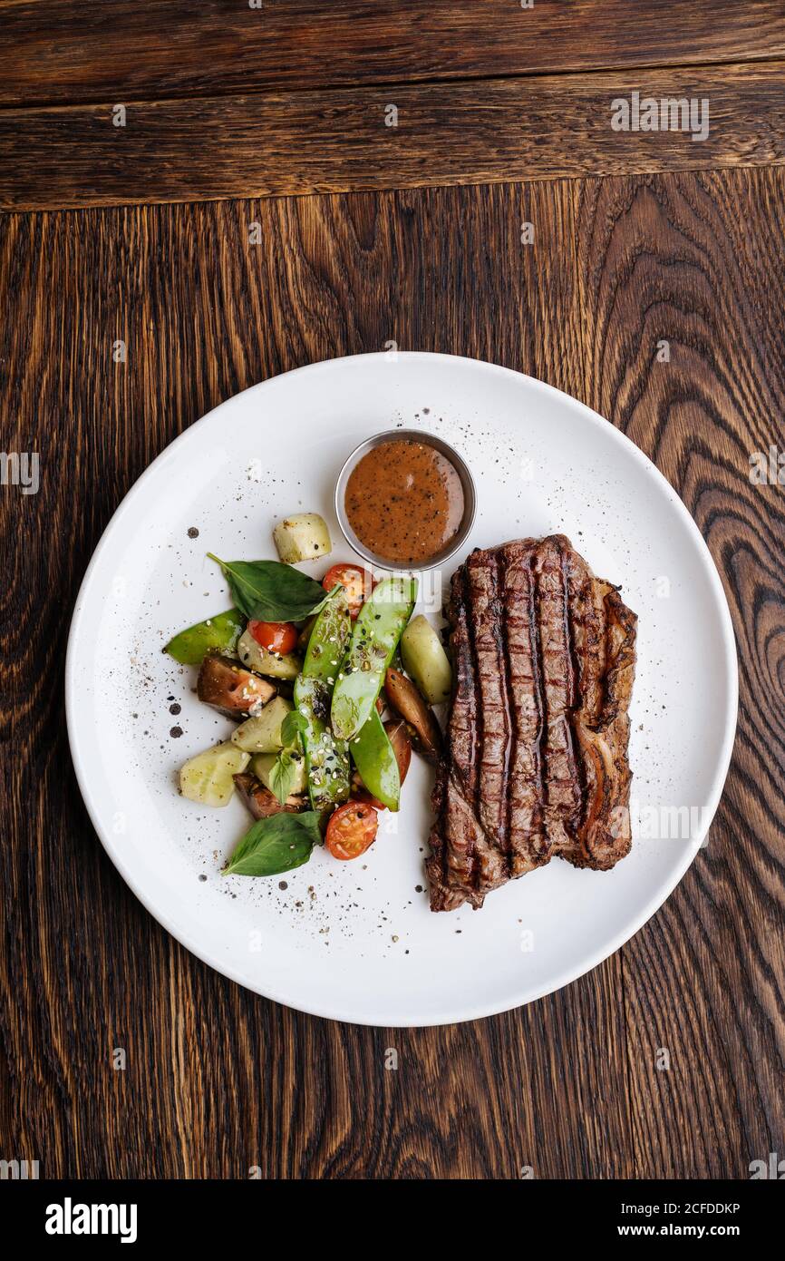 From above top view of grilled beef steak with basil and vegetable ...