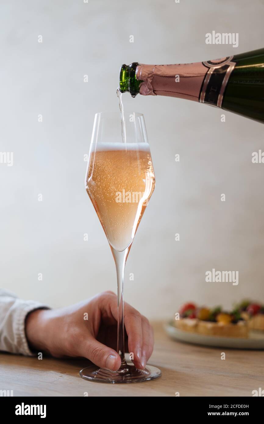 Crop client holding glass and waiting while crop bartender pouring ...