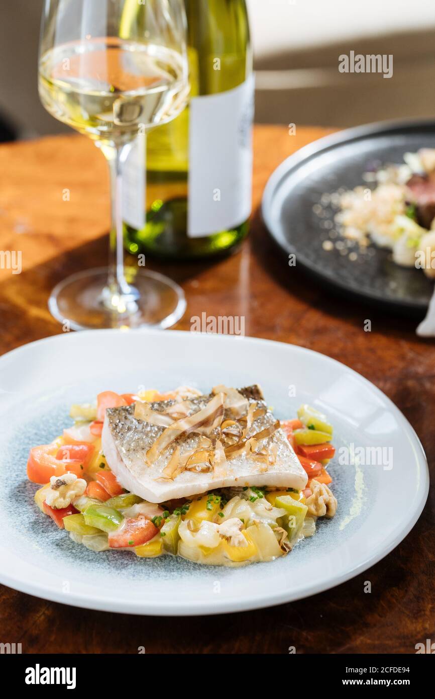 From above of fillet fish with small square slices of peppers on plate ...