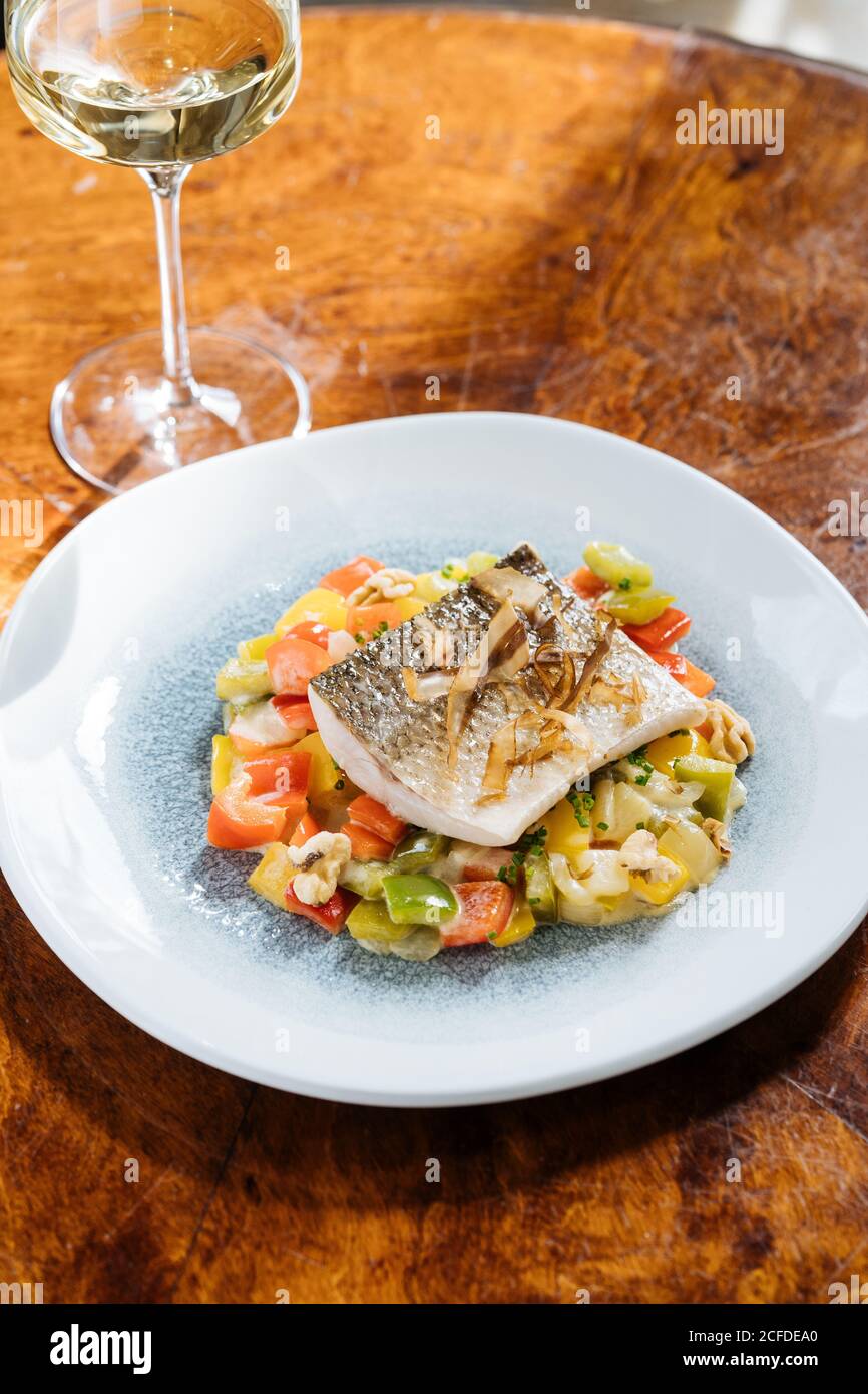 From above of fillet fish with small square slices of peppers on plate ...
