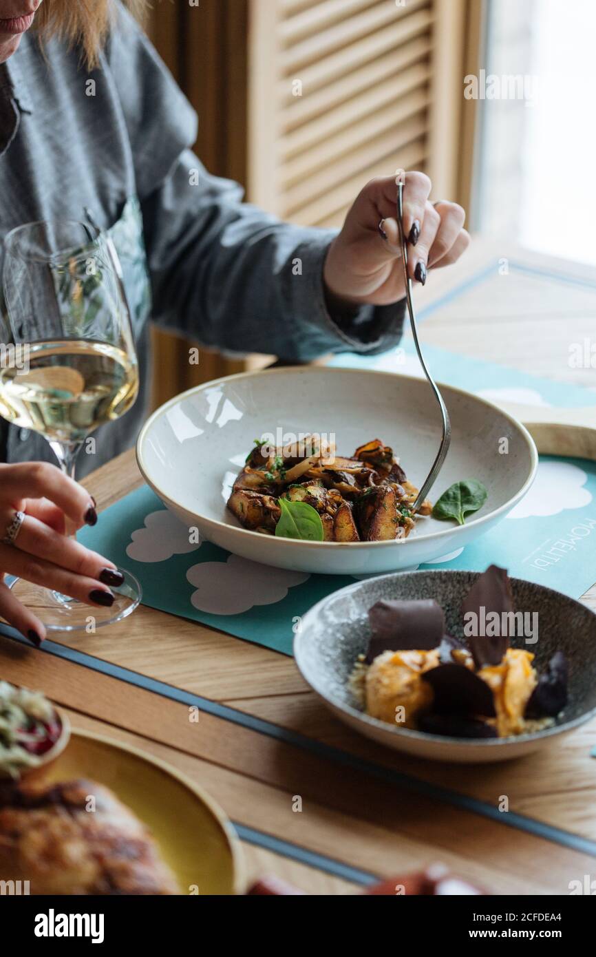 From above of crop person hand eating high cuisine dish on table with a ...