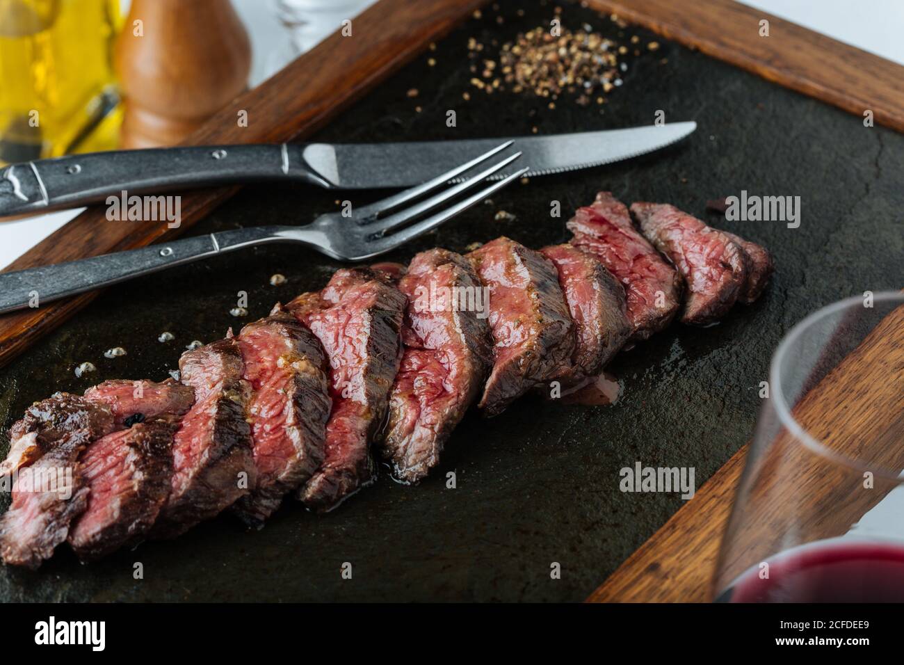 Top view of medium rare slices steak on table with fork and knife in ...