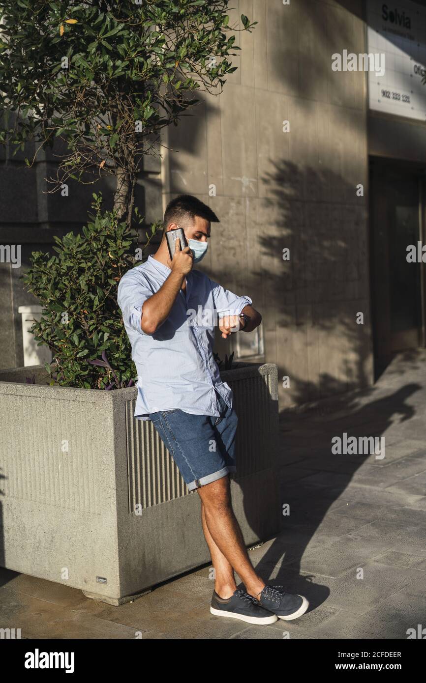 Young male in a medical mask talking on phone - the concept of new ...