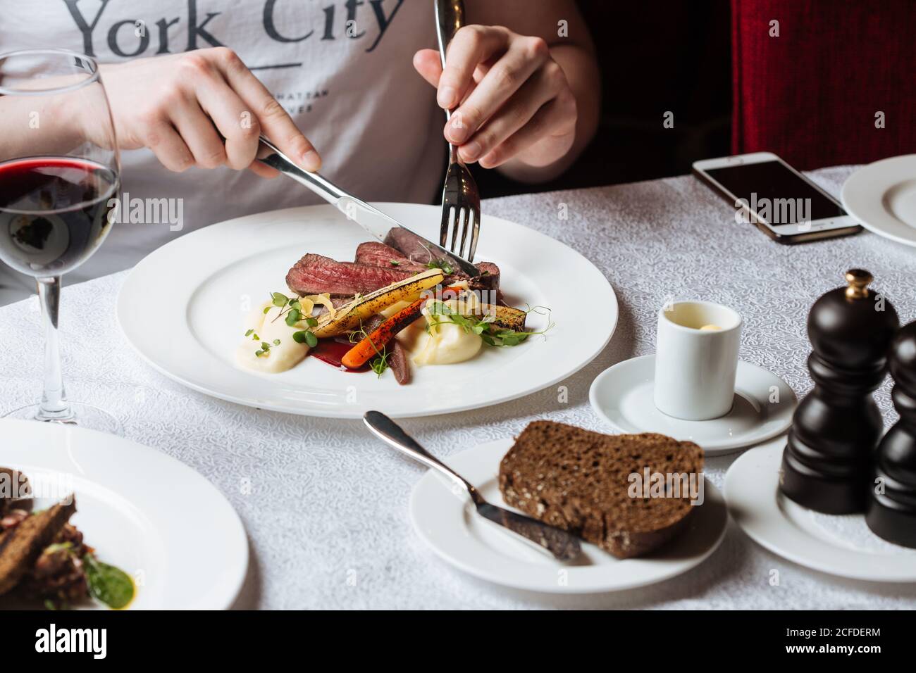 Crop man eating delicious meat steak with vegetables during dinner in ...