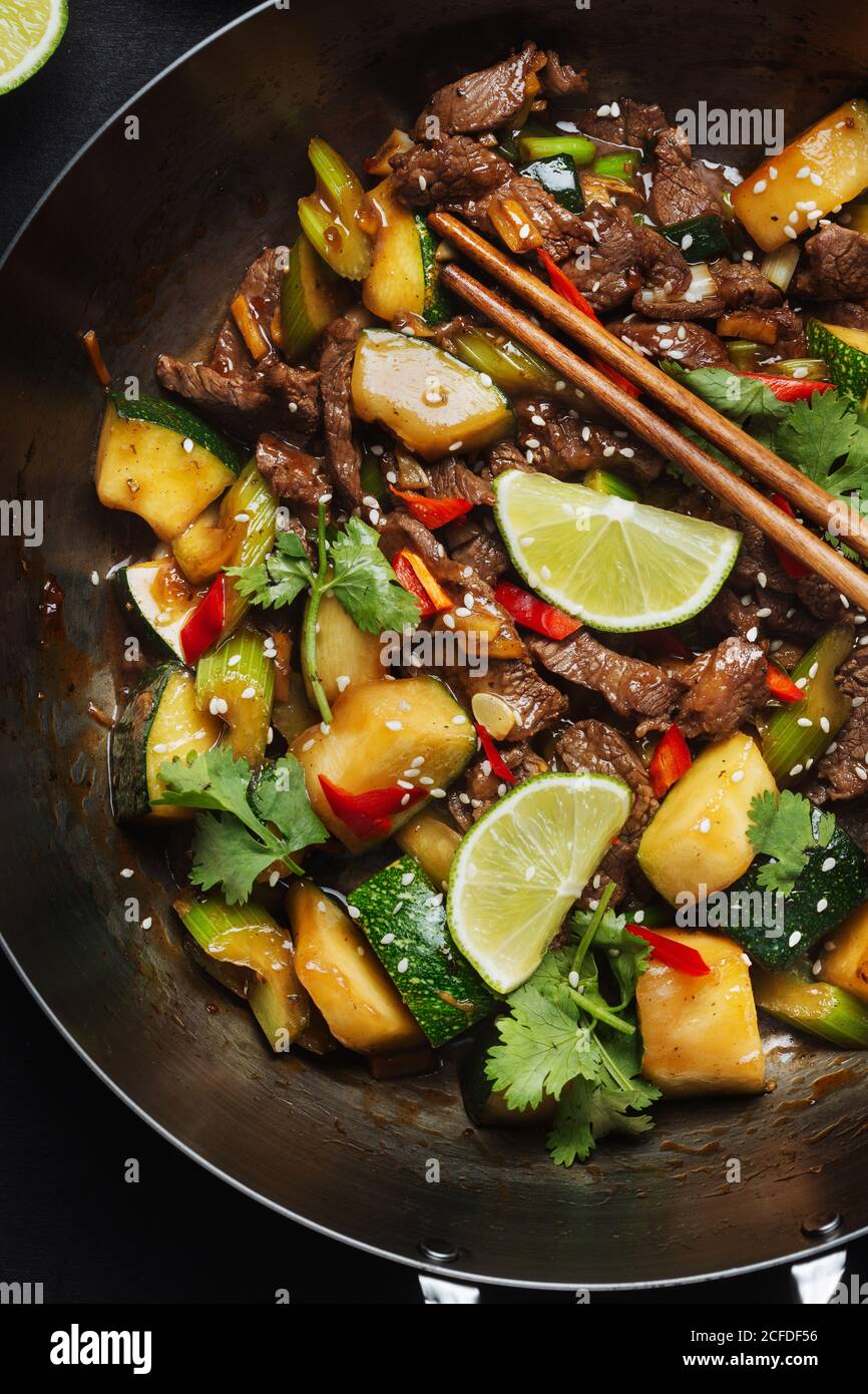 From above of Asian spicy wok stir fried dish with meat and zucchini ...