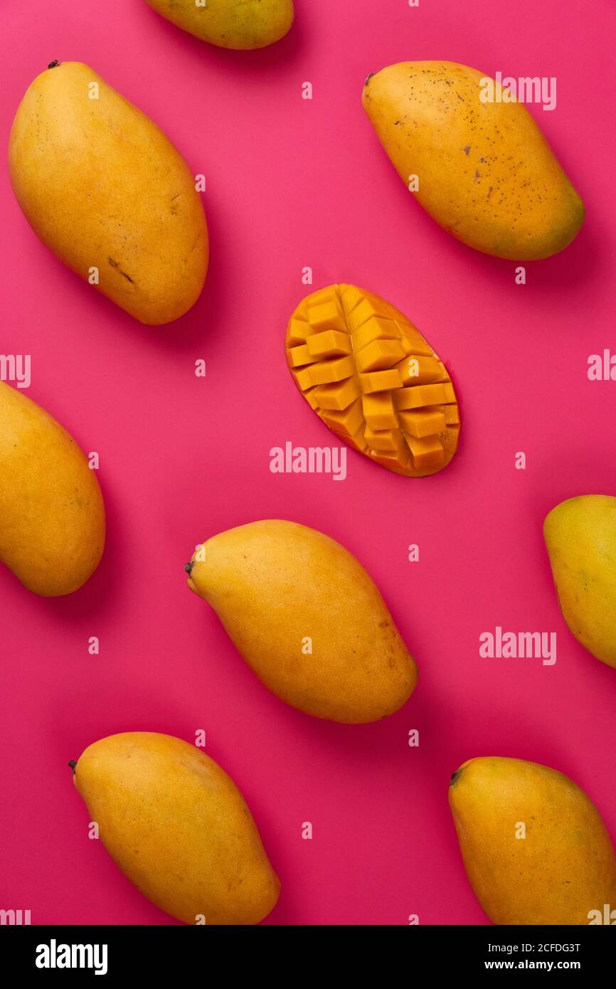 Flat lay mango fruit sliced in half cubes in pink colorful cardboard ...