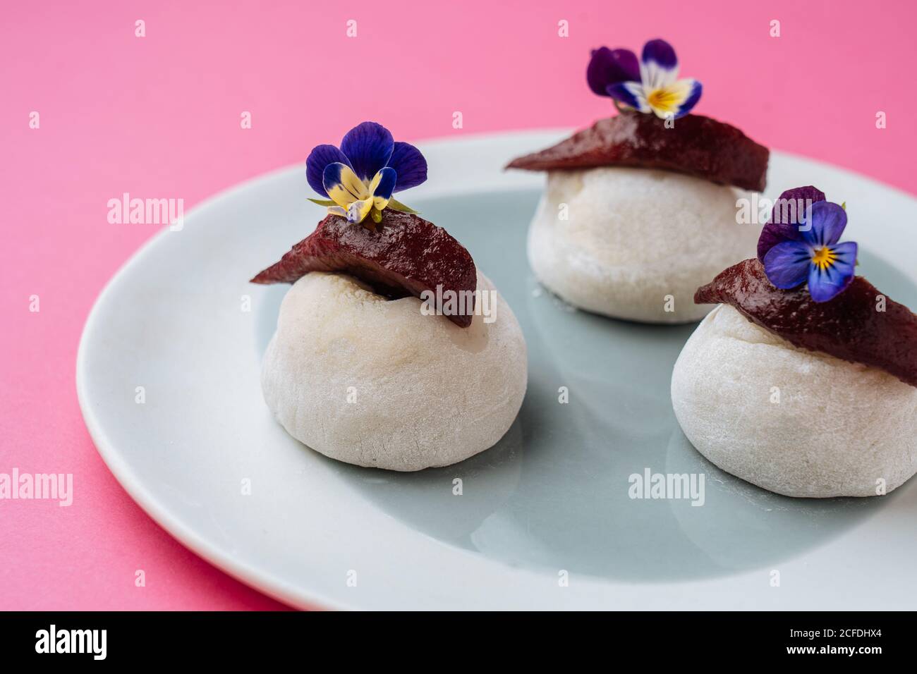 Rock shaped pastry decorated with berry marmalade and flowers and ...