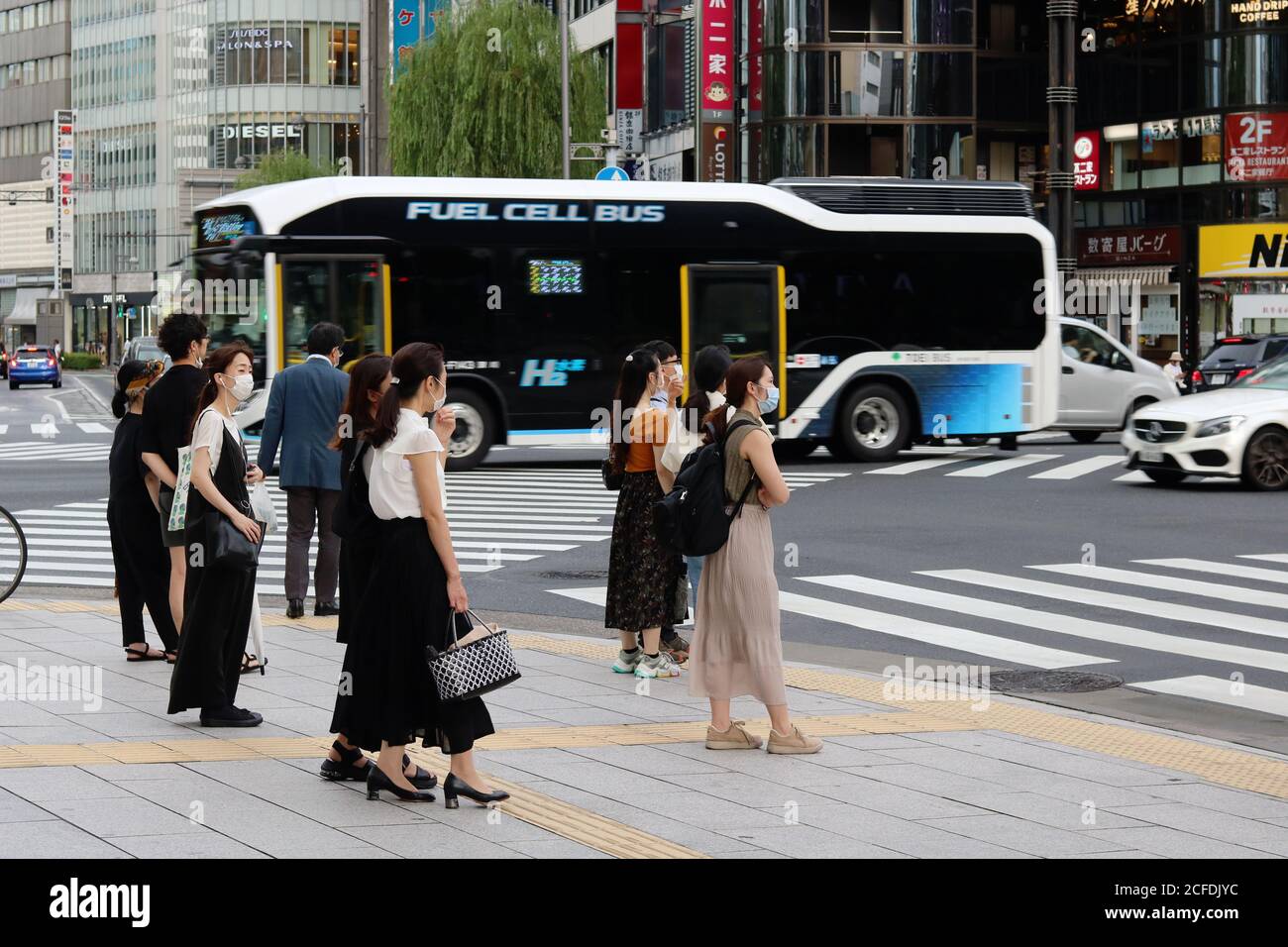 People wait to cross Sukiyabashi scramble crossing in Ginza as a fuel ...