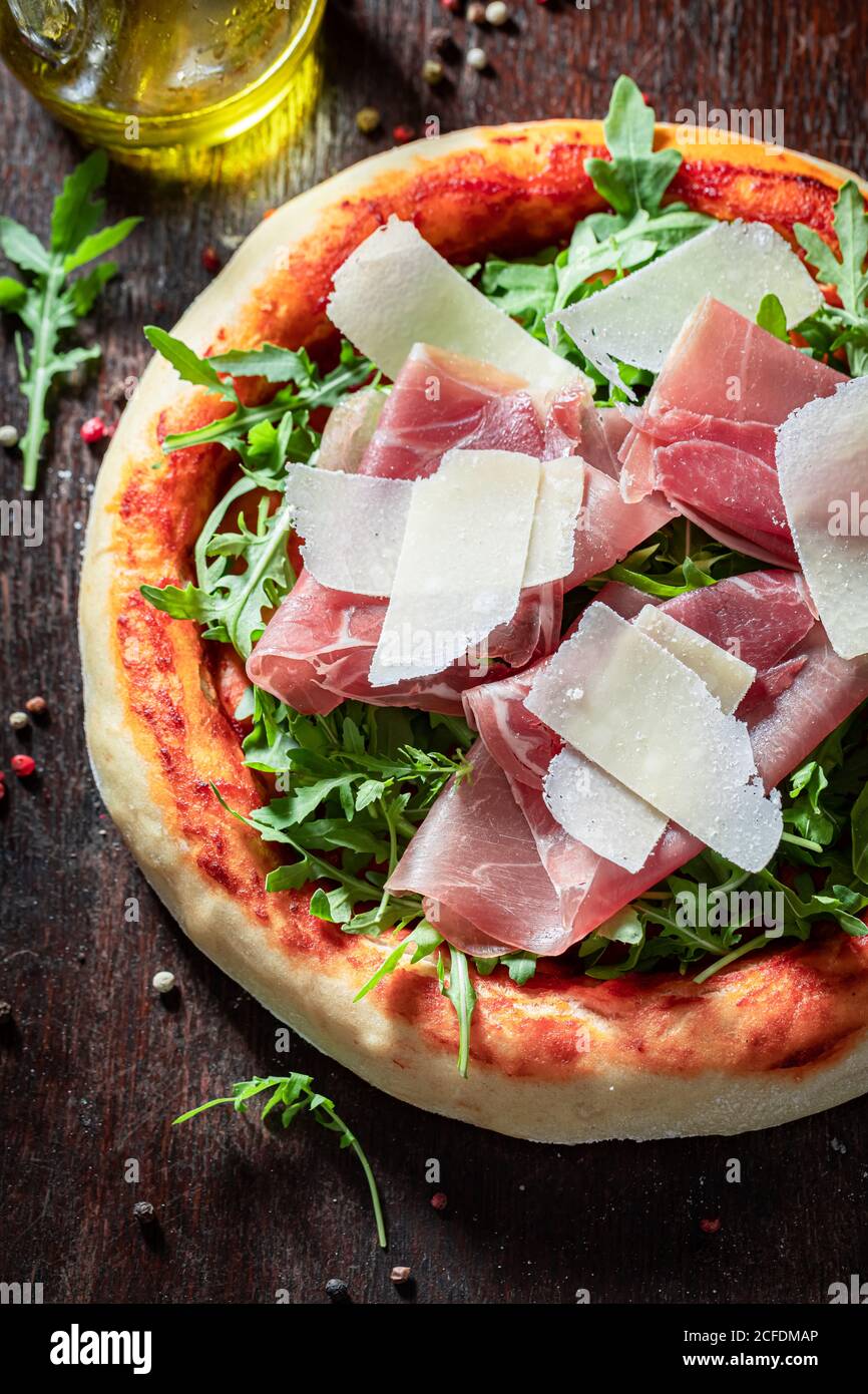 Homemade pizza Parma with parmesan cheese and parma ham on wooden table ...