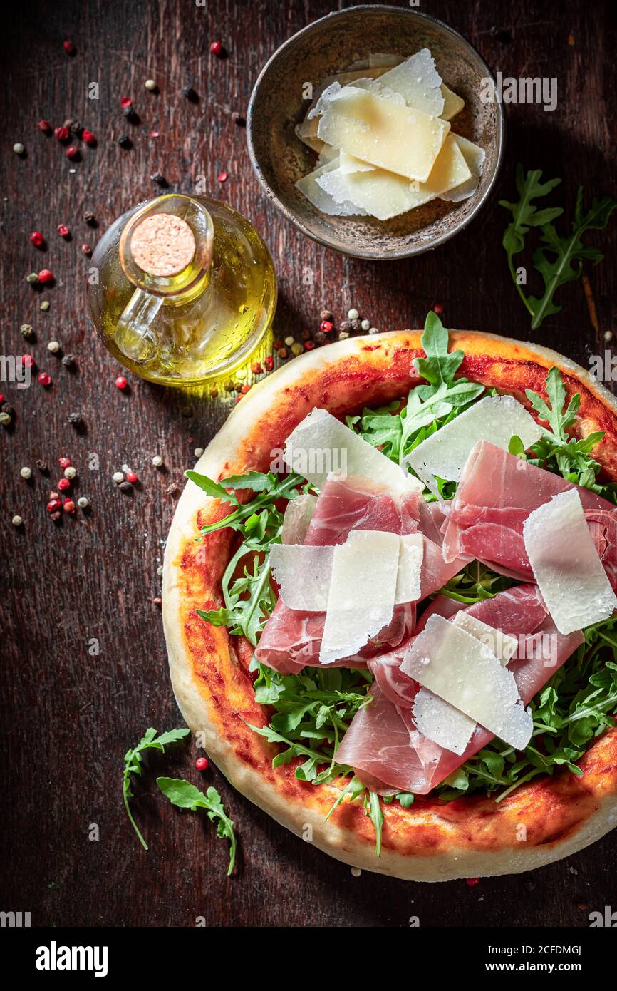 Delicious pizza Parma with parmesan cheese and parma ham on wooden ...