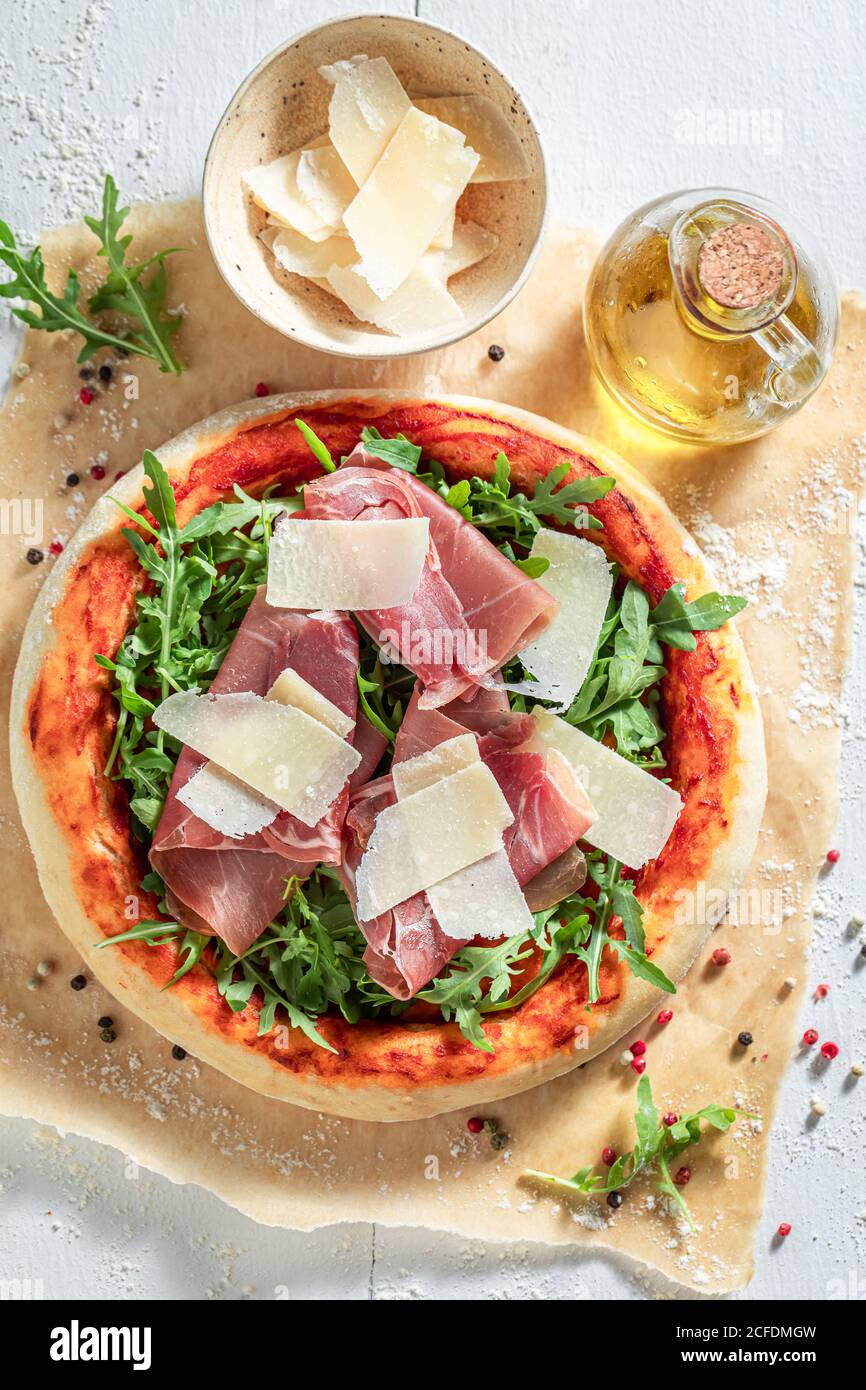 Tasty pizza Parma with parmesan cheese and parma ham on wooden table ...