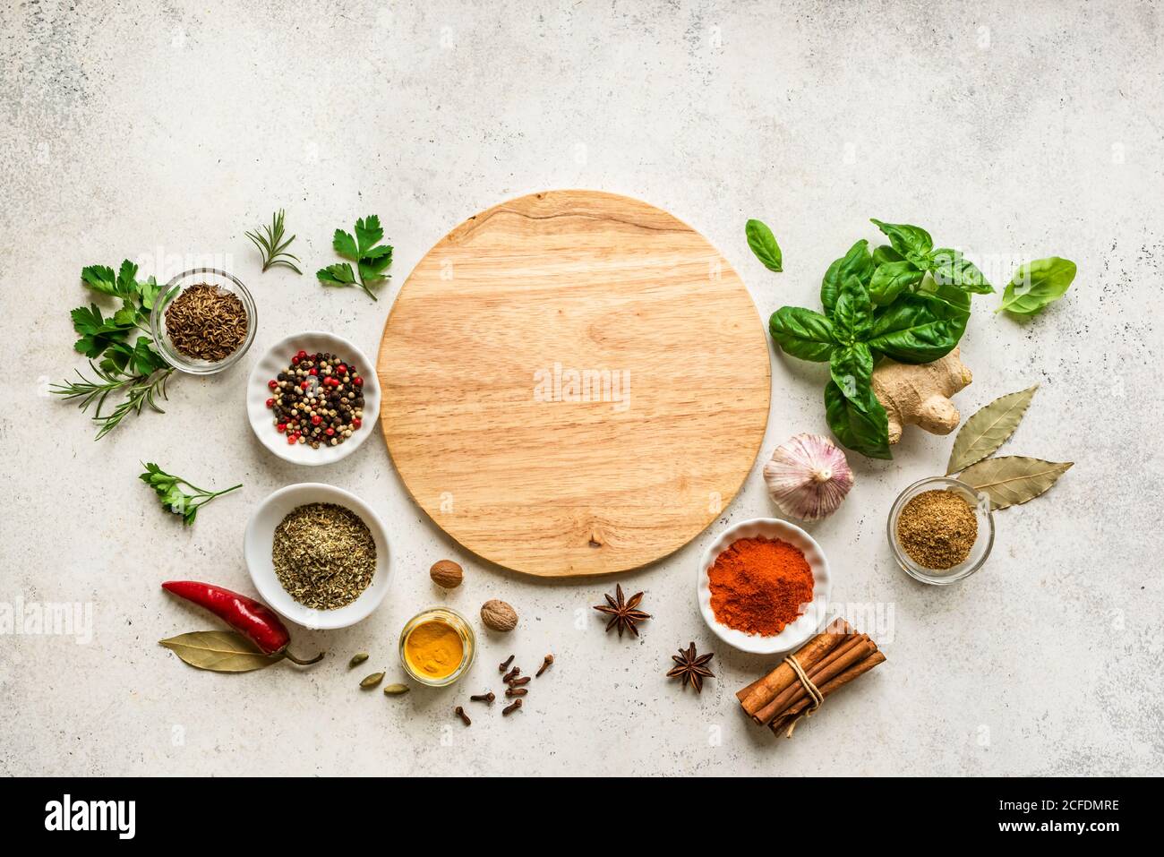 Various Spices, Herbs and Condiments around plate on white stone table ...