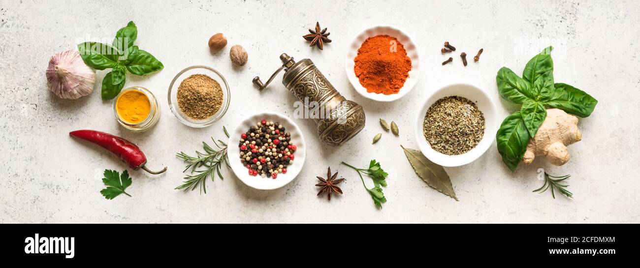 Various Spices, Herbs and Condiments around plate on white stone table ...