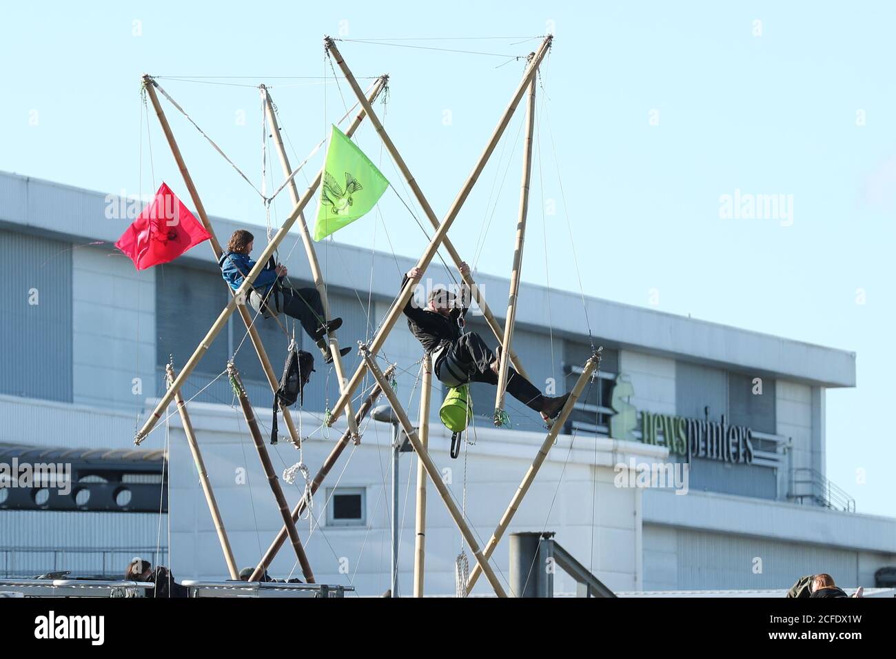 Two protesters use bamboo lock-ons to block the road outside the ...