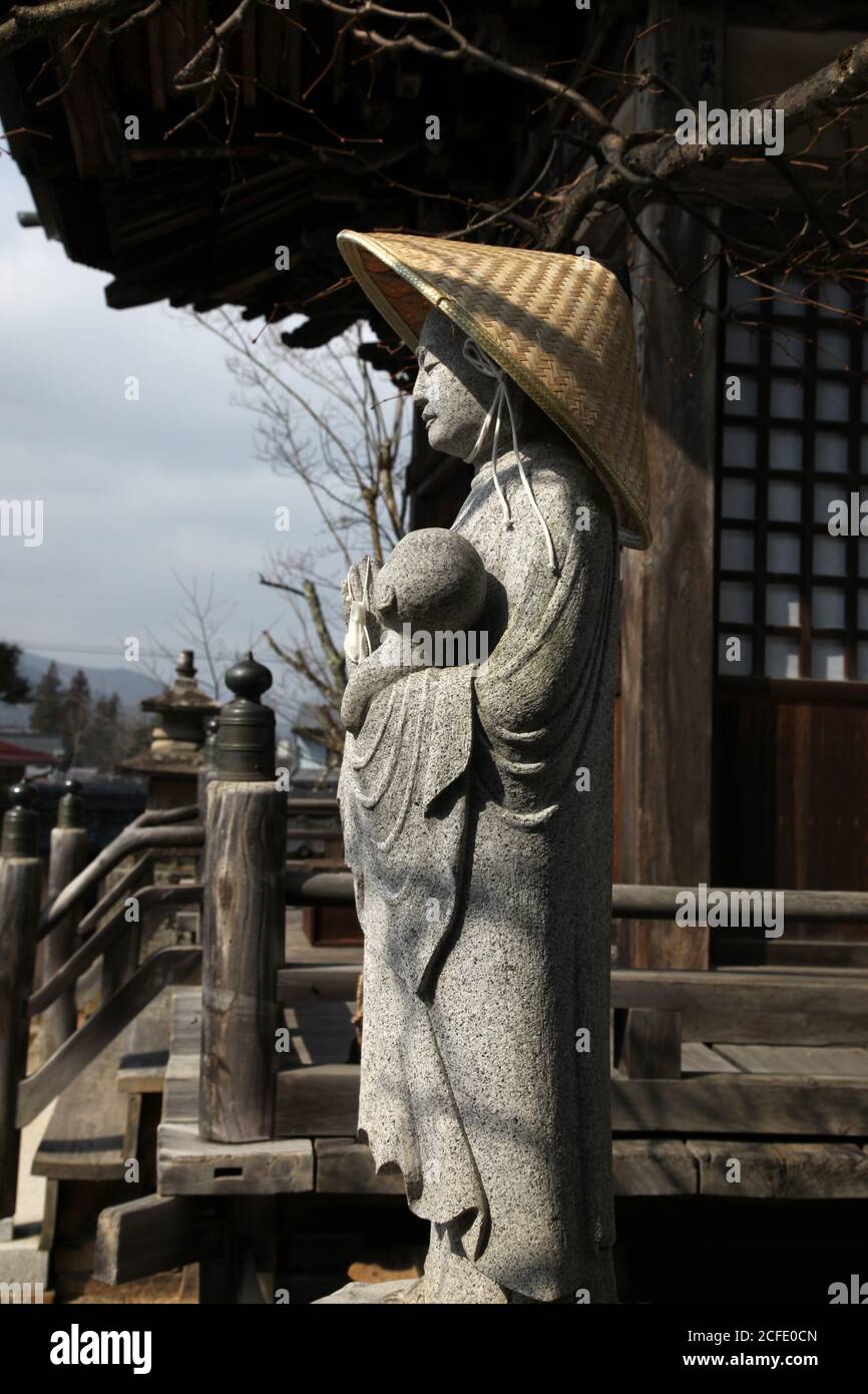 A religious statue outside a traditional Japanese Temple in Takayama ...