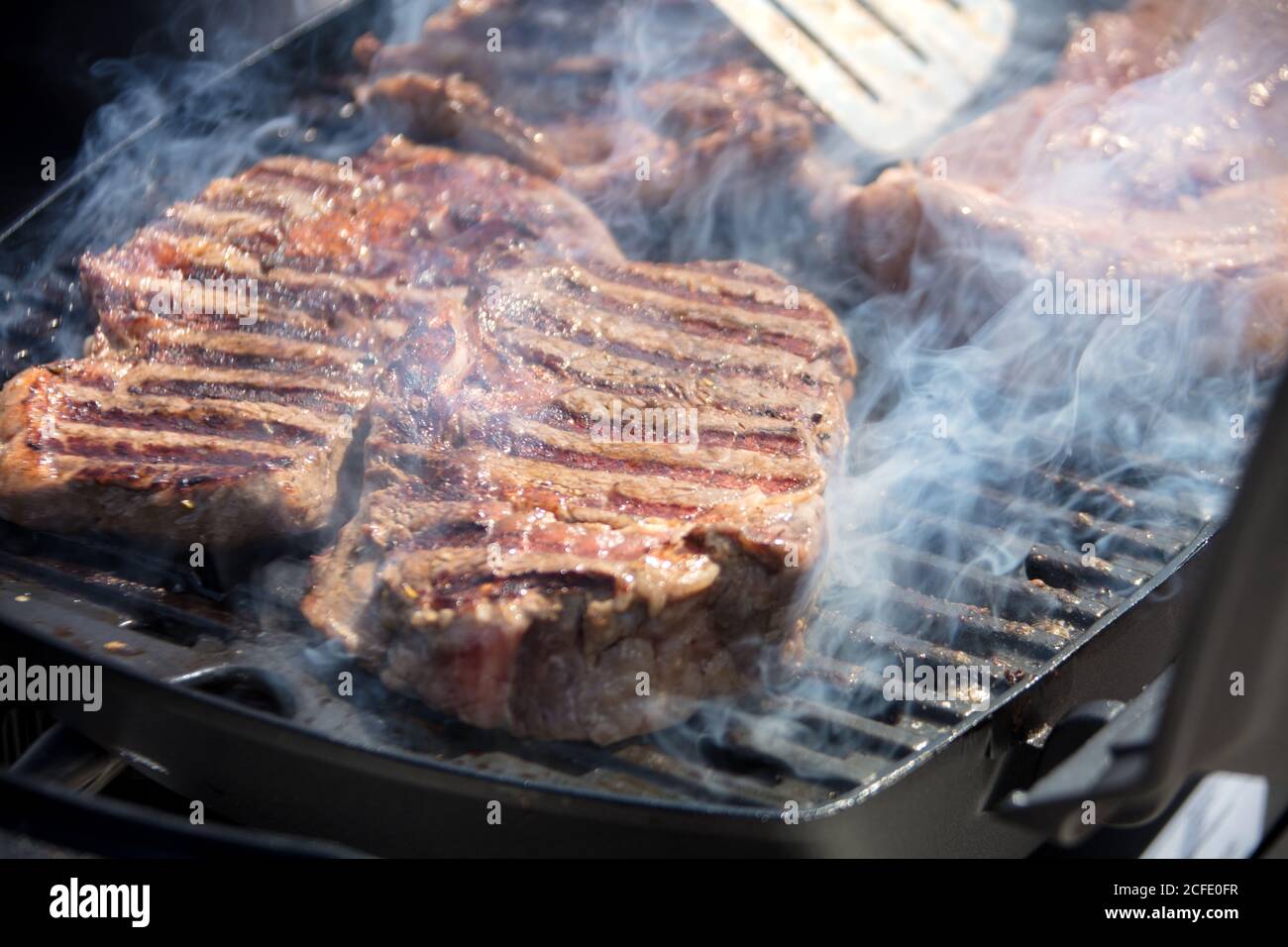Grilled meat with smoke Stock Photo - Alamy