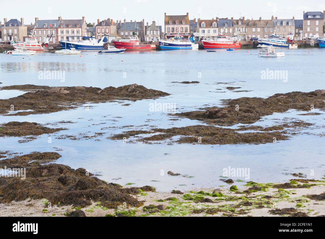 Boats in Barfleur harbor at low tide. The town is one of the most ...
