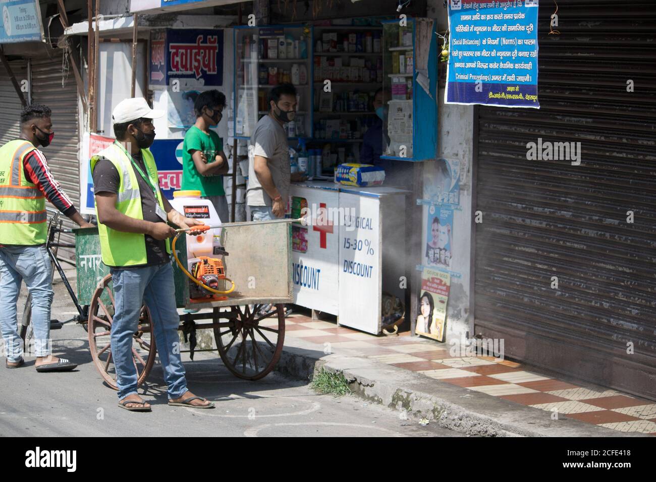 Municipal worker sanitizes a shop, wearing face mask Stock Photo - Alamy
