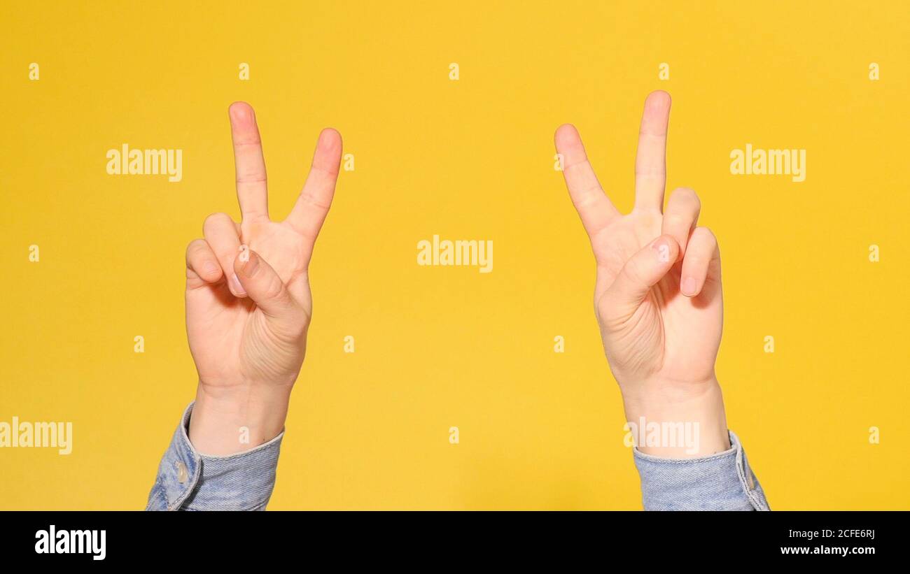Man Hand Showing Victory Sign with Fingers Isolated on yellow ...