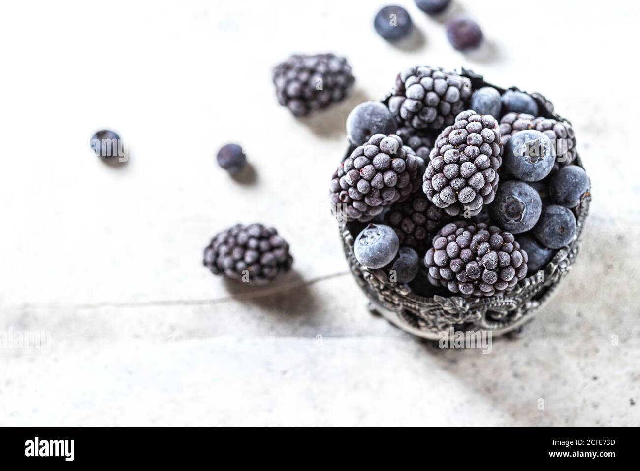 Fresh Frozen blackberry on a gray concrete background. Season concept ...