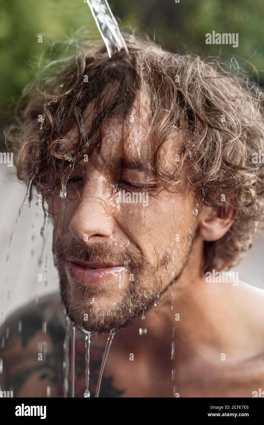 Freestyle. Man with curly hair sitting outdoors joyful while friend ...