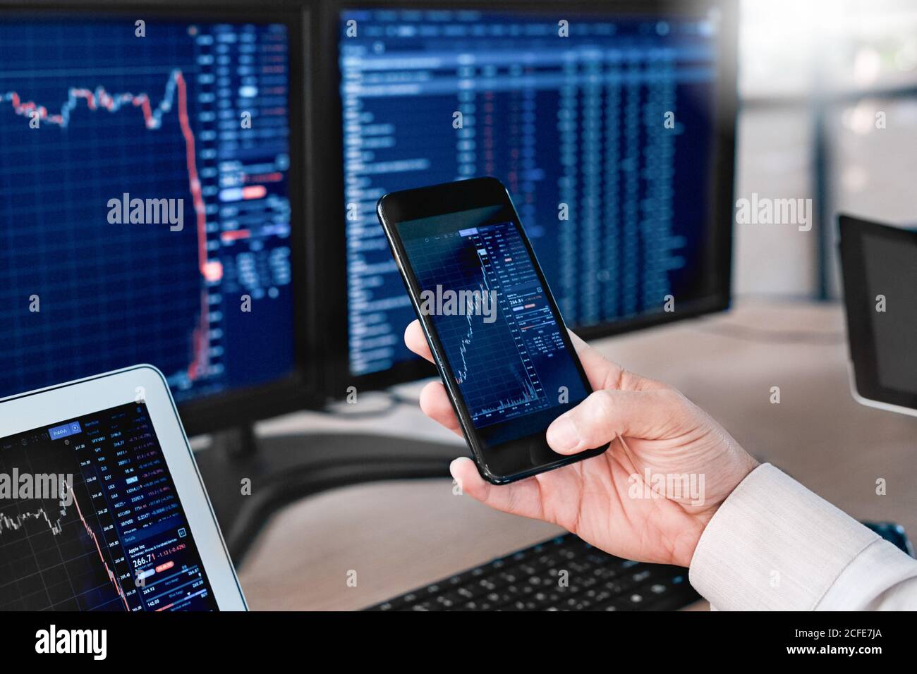 Stocks and Funds. Trader sitting at office in front of monitors with ...