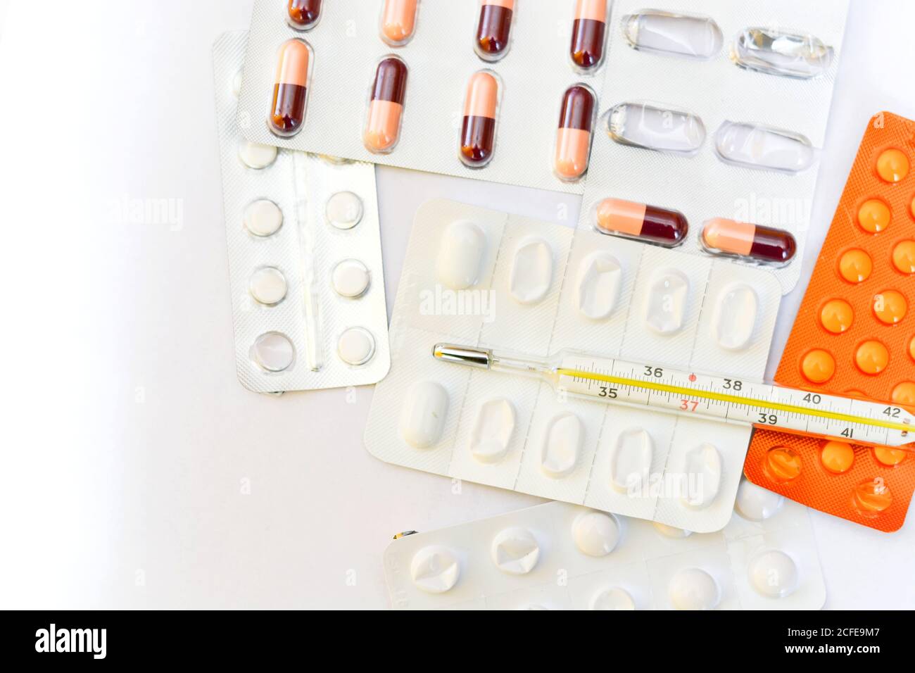 Termometer and medical pills on white background Stock Photo - Alamy