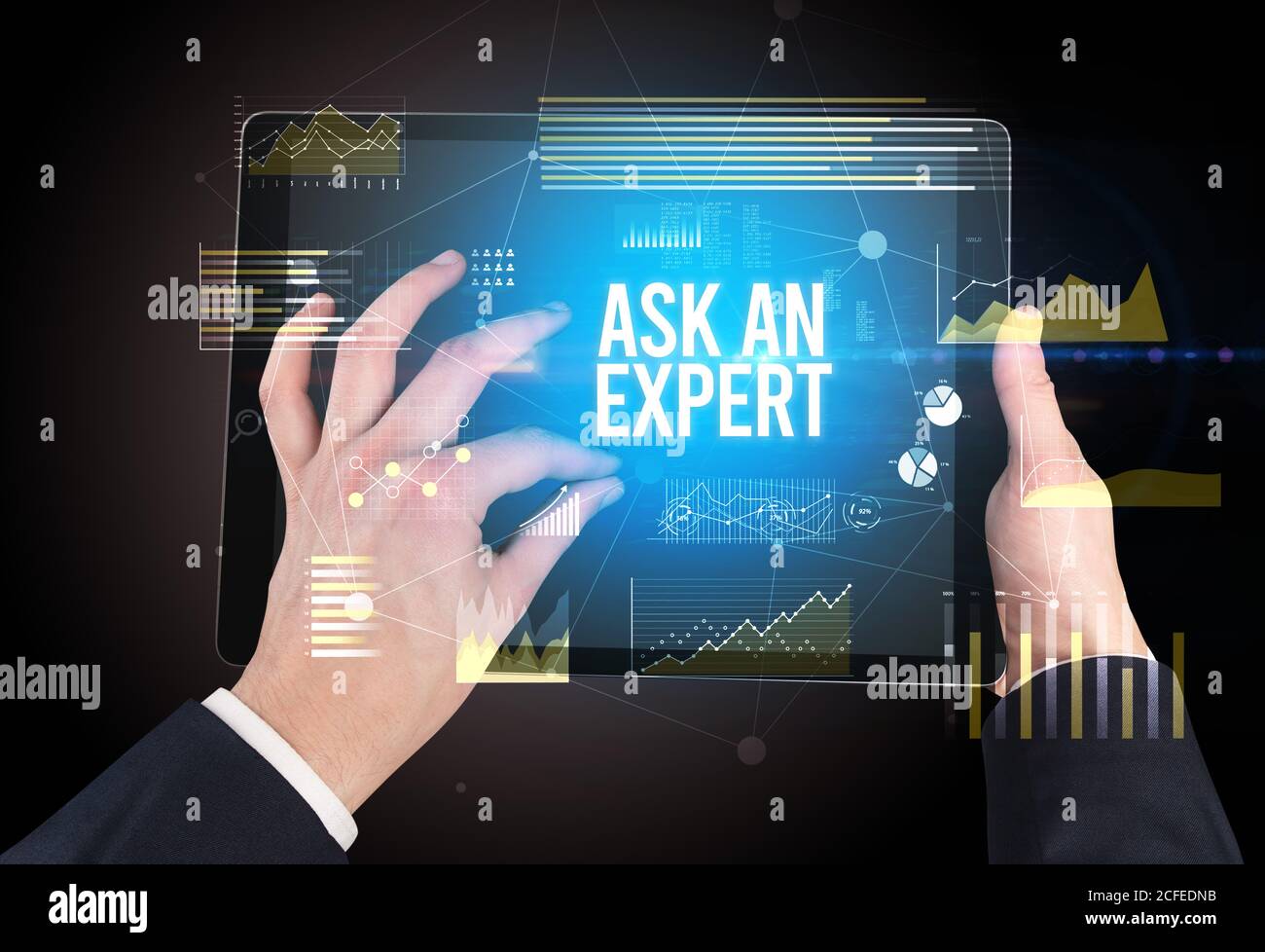 Close-up of hands holding tablet with ASK AN EXPERT inscription, modern ...