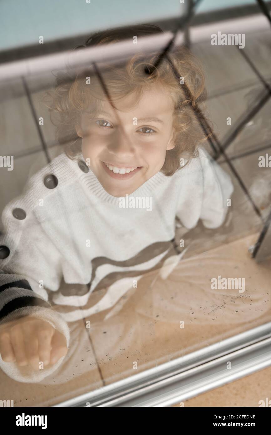 Happy boy standing behind window Stock Photo - Alamy