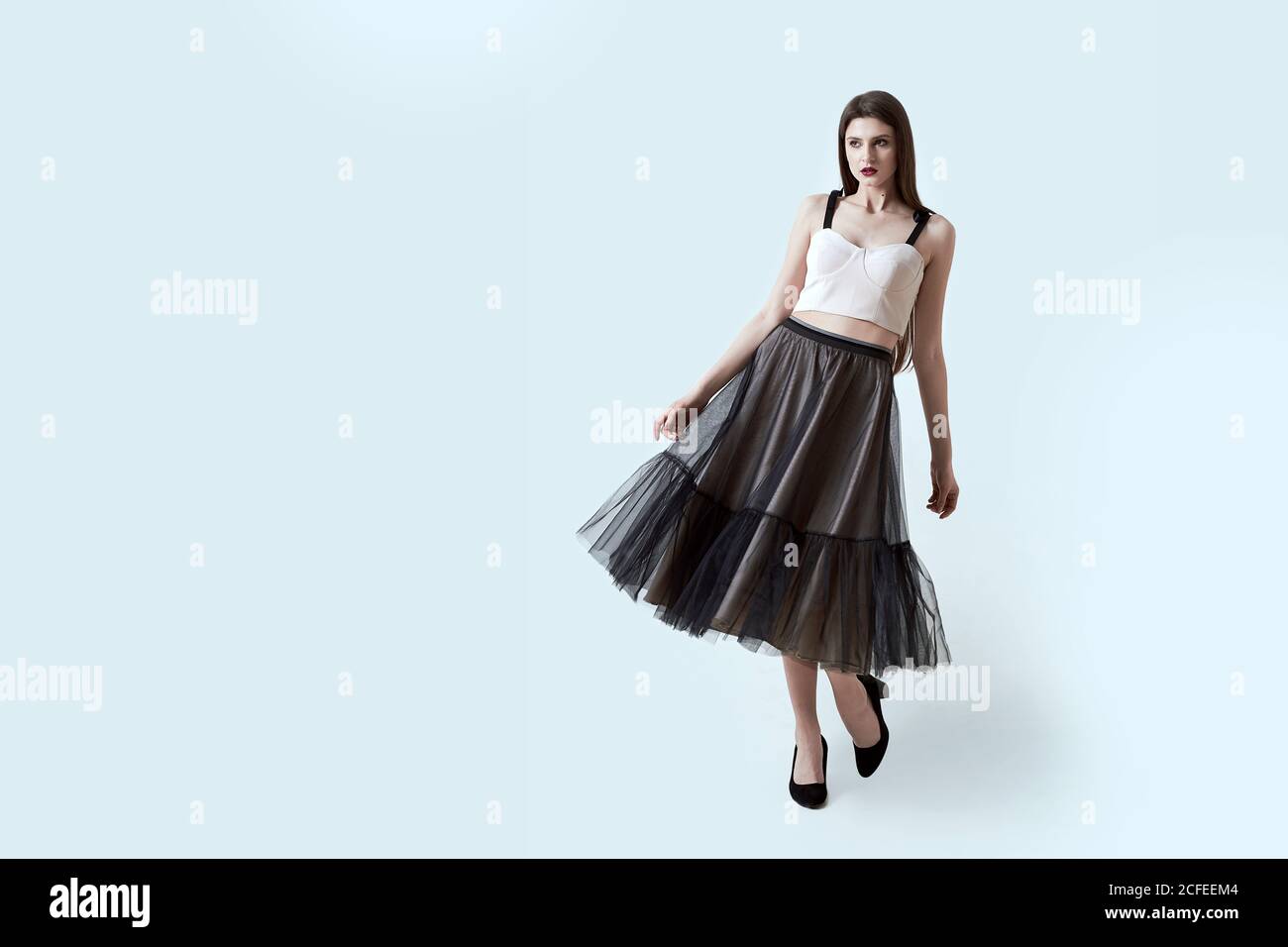 Young beautiful brunette girl in waving dark box pleated midi skirt ...