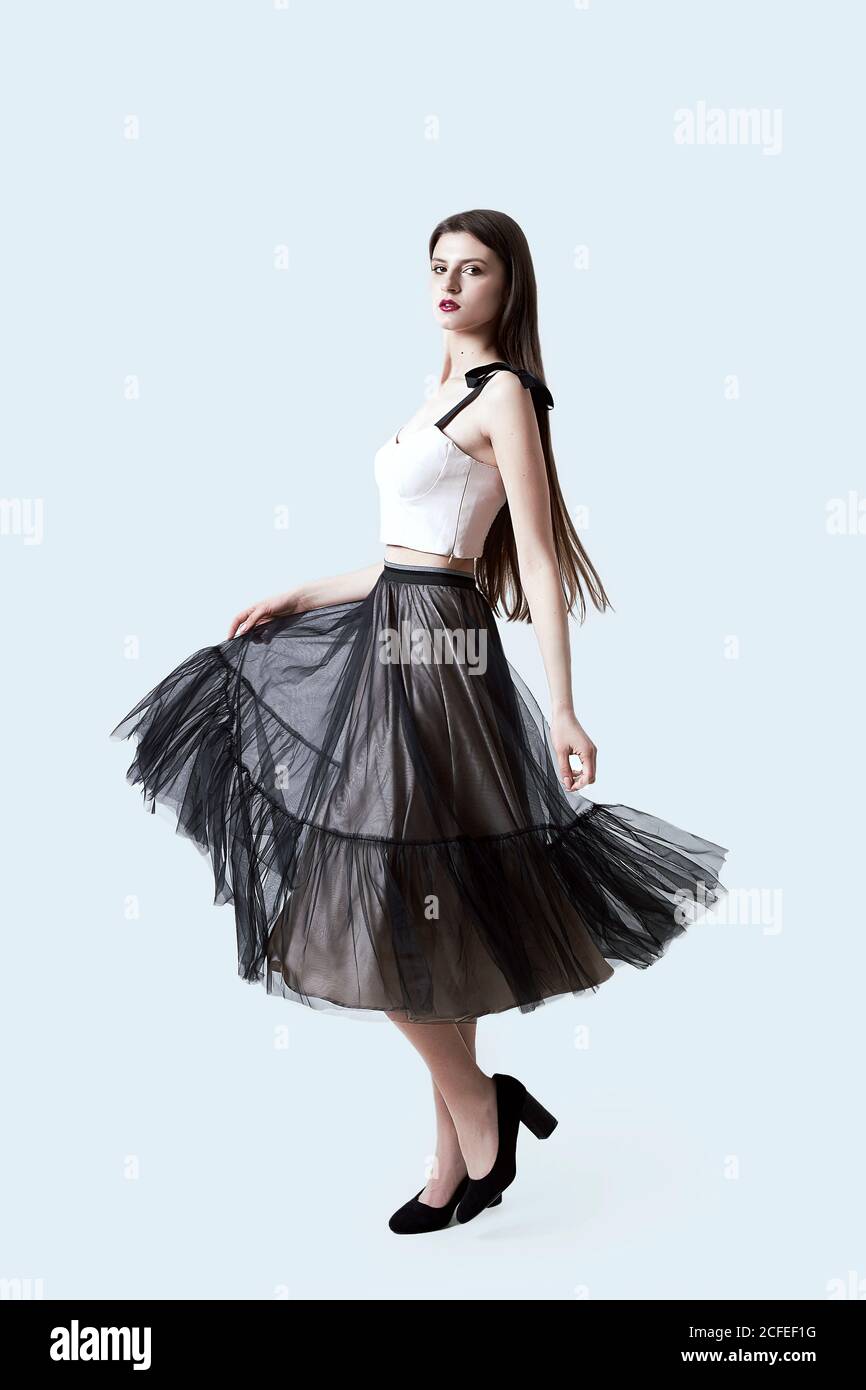 Young beautiful brunette girl in waving dark box pleated midi skirt ...