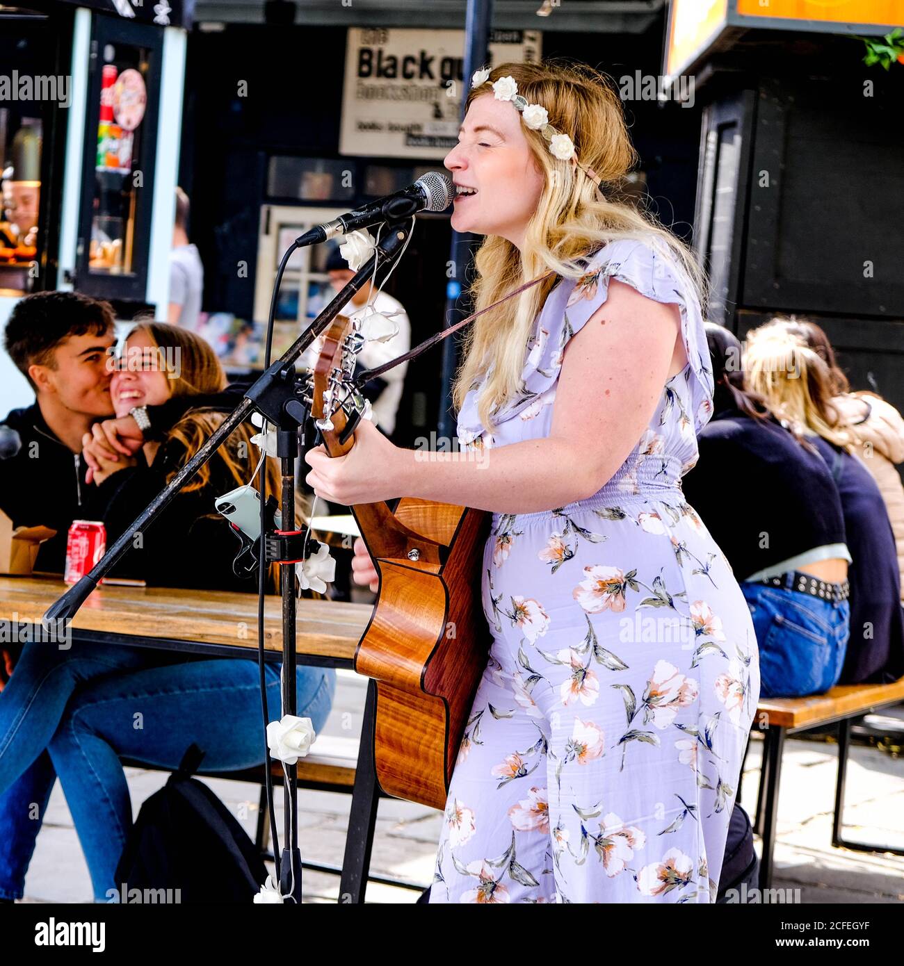 Woman playing guitar singing busking hi-res stock photography and ...