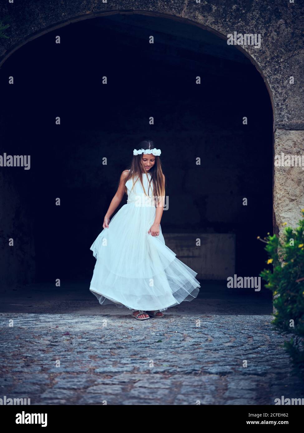 Adorable little girl in airy long white dress and flower headband ...