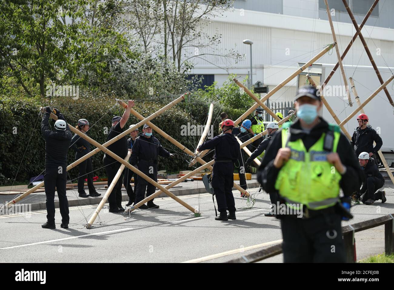 Emergency services dismantle the bamboo lock-ons used to block the road ...