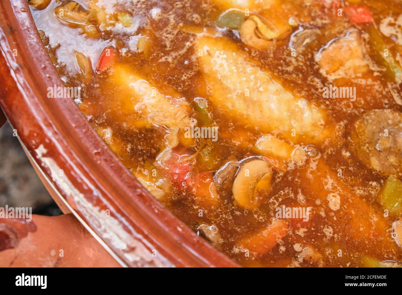 From above view of large clay cooking pot with rice chicken assorted ...