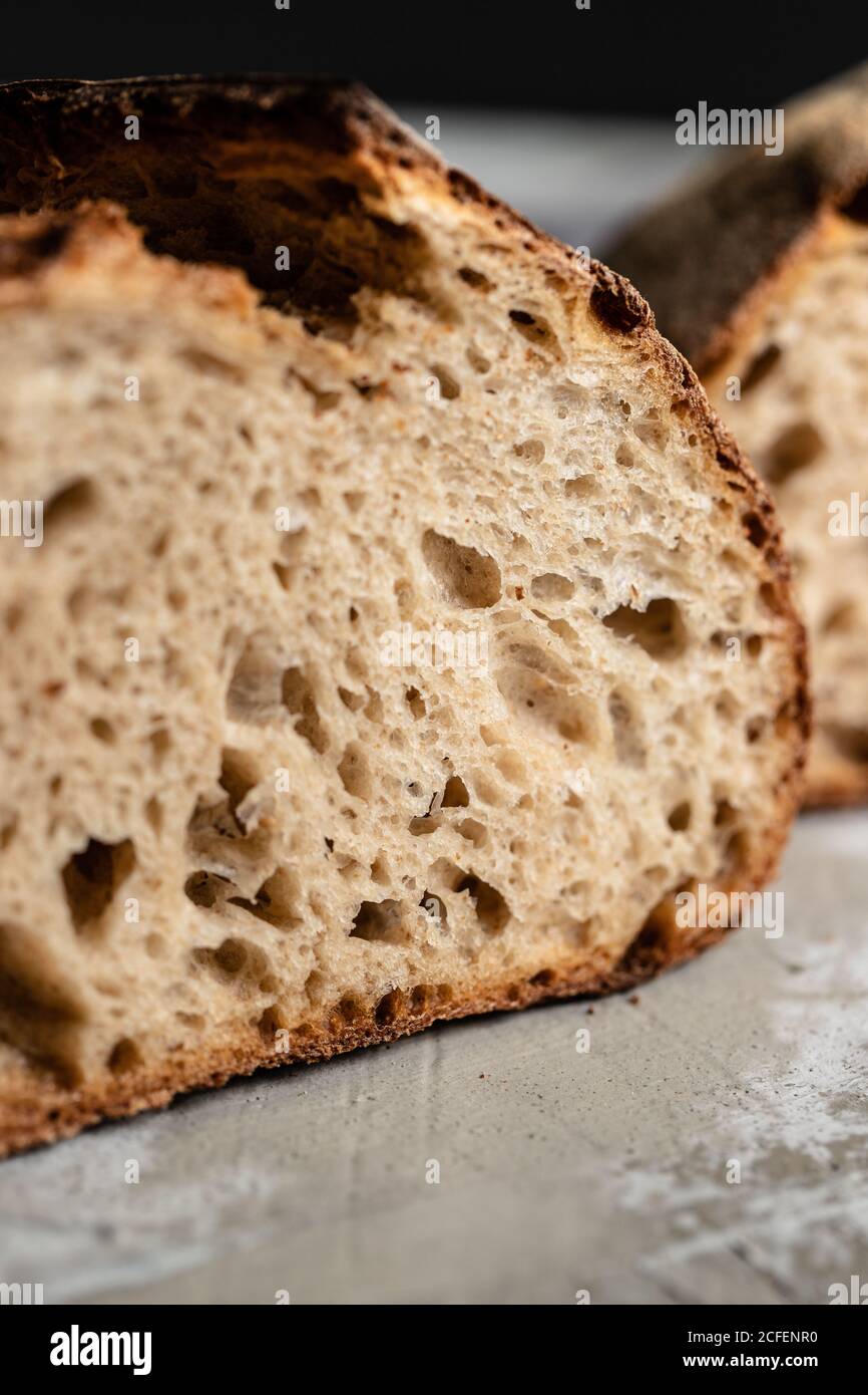 Closeup of cut fresh homemade wholegrain bread loaf with crispy crust ...